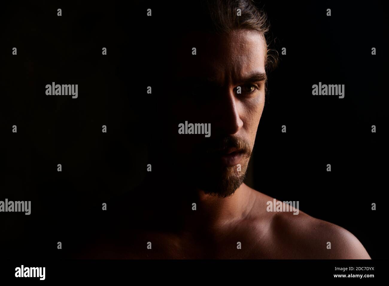 Handsome young man with half of face in shadow Stock Photo - Alamy