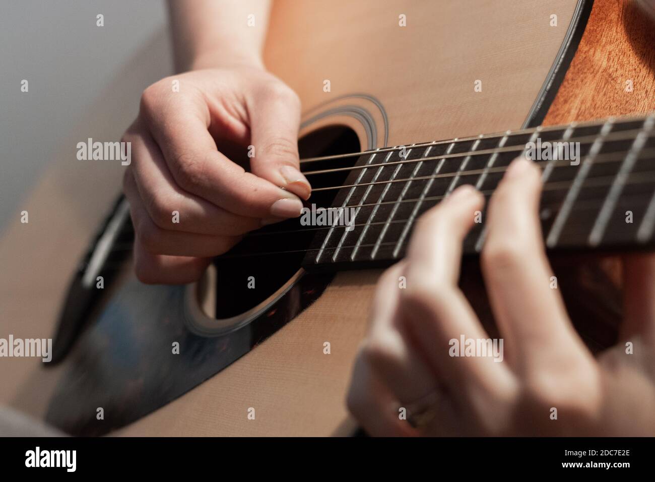 A female hand plucking a western guitar Stock Photo - Alamy
