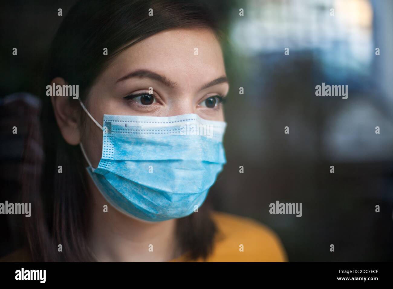 Anxious depressed and stressed young woman wearing medical face mask,in ...