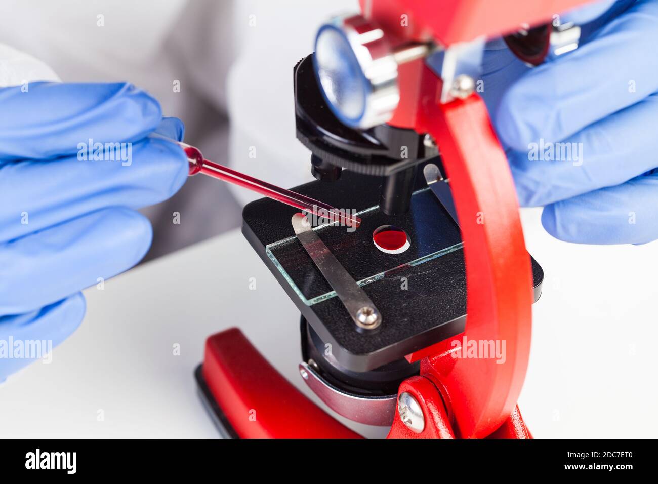 Lab scientist or medical technologist placing a drop of blood sample on ... Lab scientist or medical technologist placing a drop of blood sample on ...