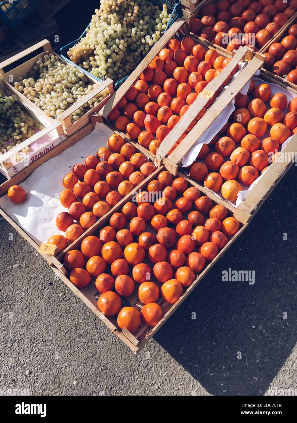 Harvest of autumn fruits. Ripe persimmon grapes in boxes Stock Photo ...