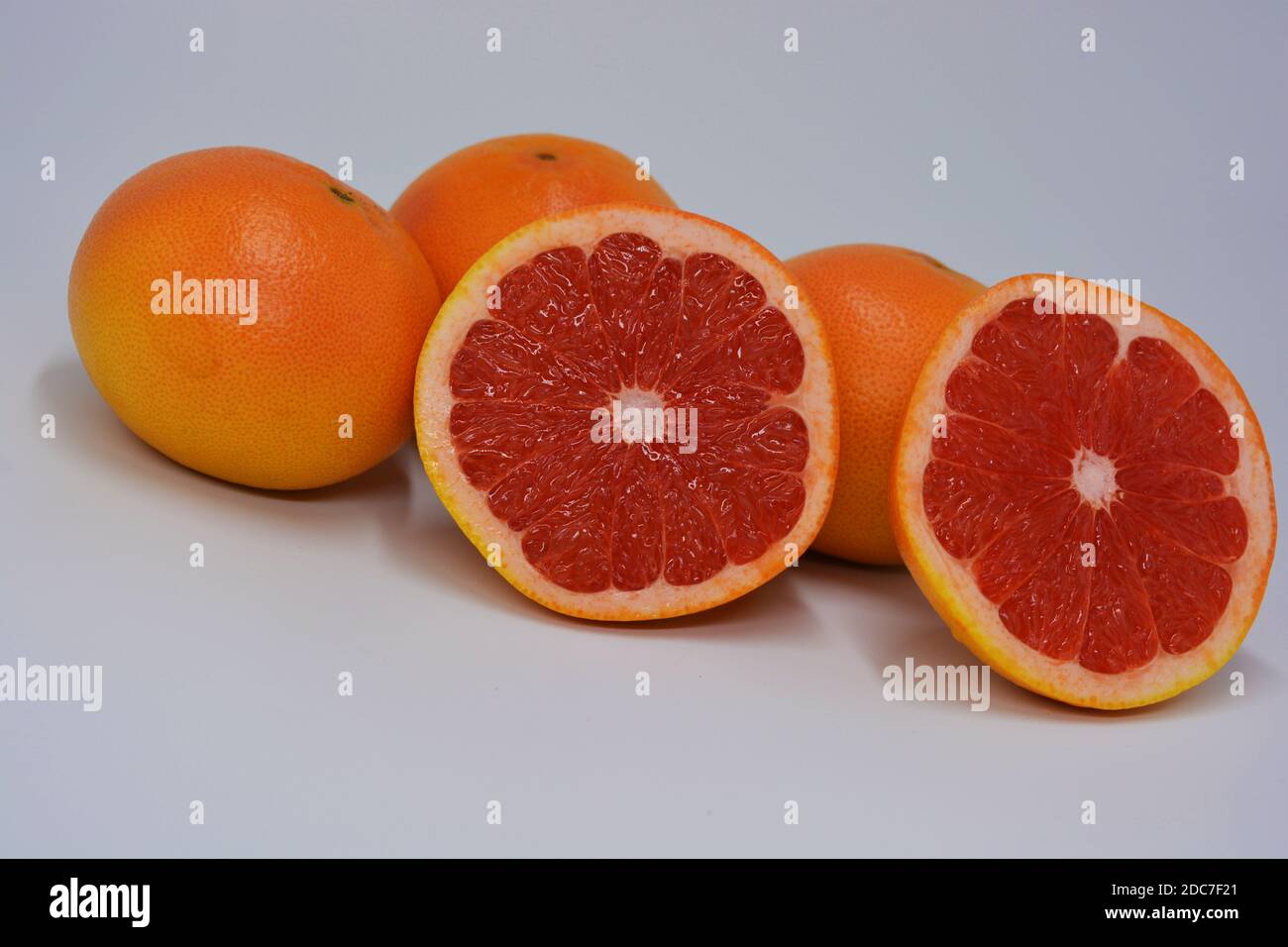 Large ripe orange-yellow grapefruits with a juicy grapefruit cut into ...