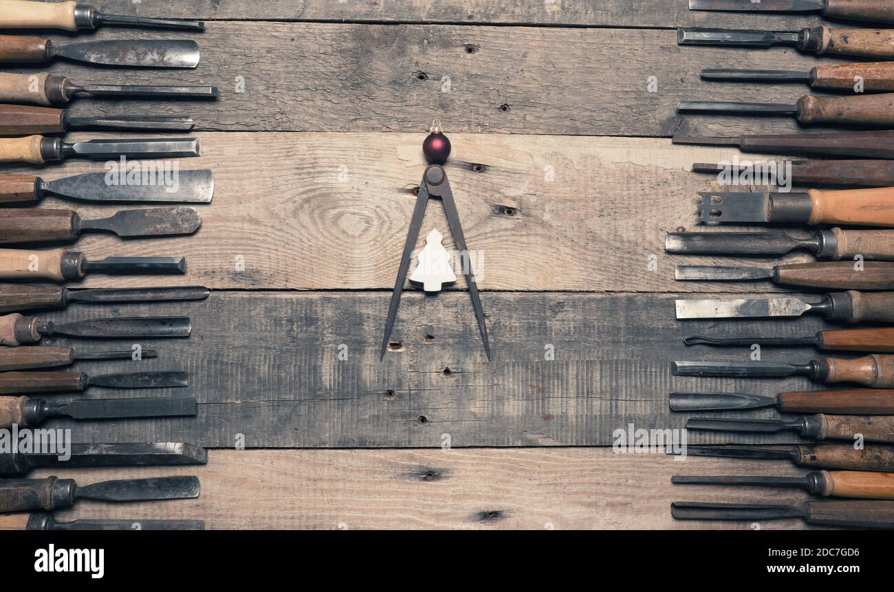 Many firmer chisels as frame on a rustic workbench, a steel compass as ...