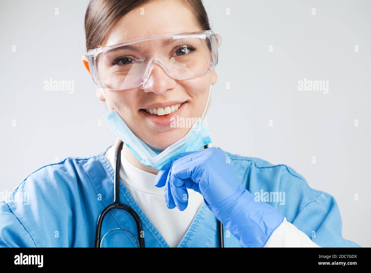 Happy doctor pulling down protective medical face mask,successful end ...