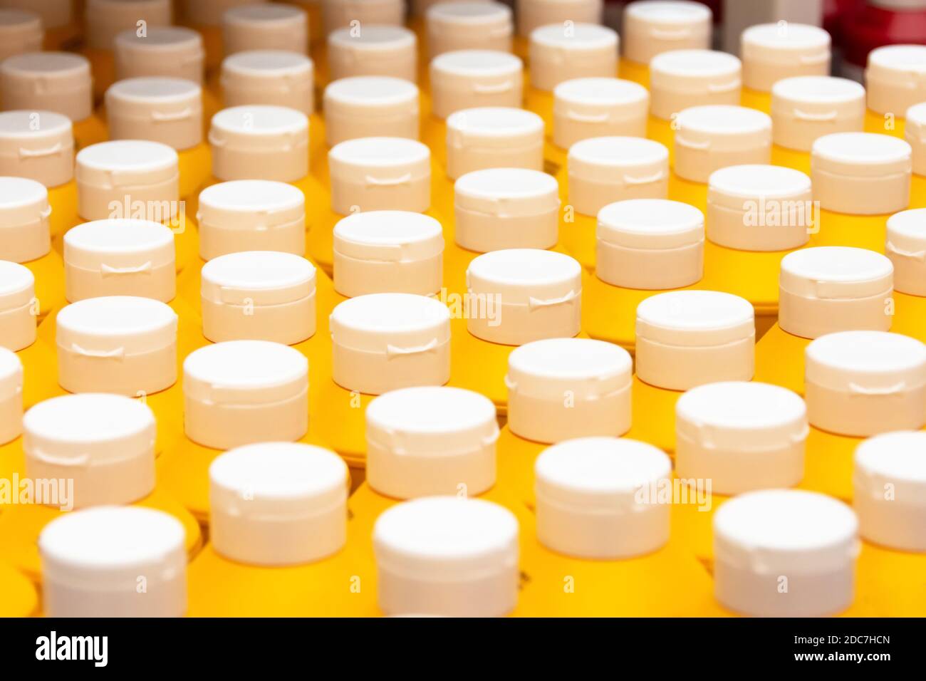 Lots of plastic yellow cans of liquid mustard on a shelf in a ...