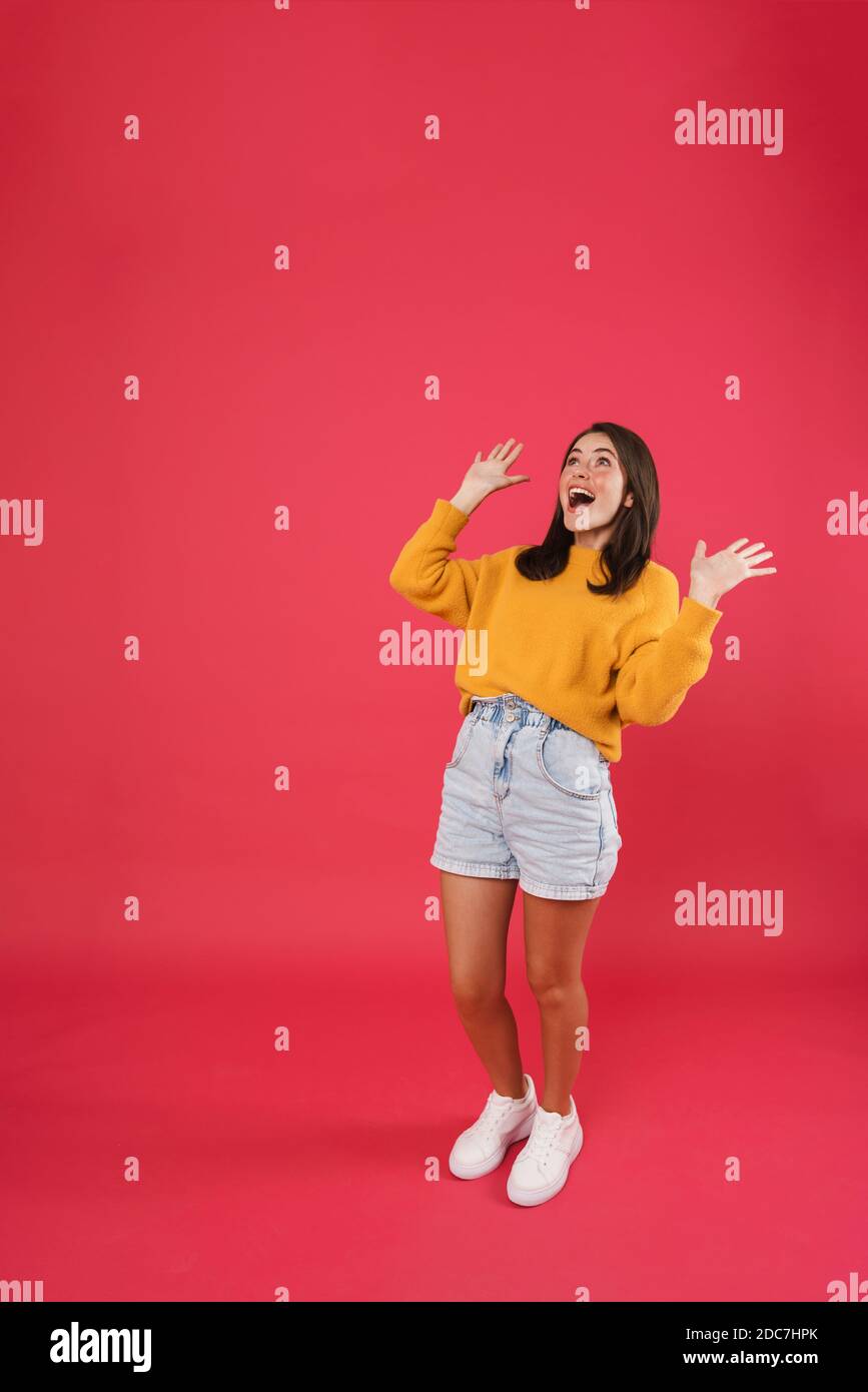 Full length of a happy woman with raised hands trying to catch ...