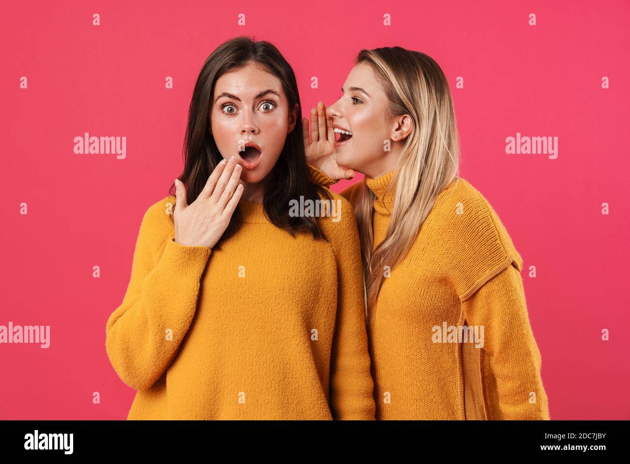 Image of beautiful woman whispering secret to shocked her friend ...