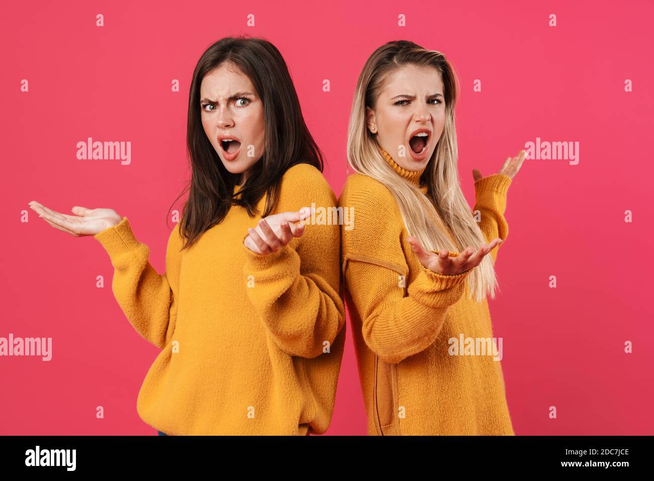 Image of furious beautiful women fighting while standing back to back ...