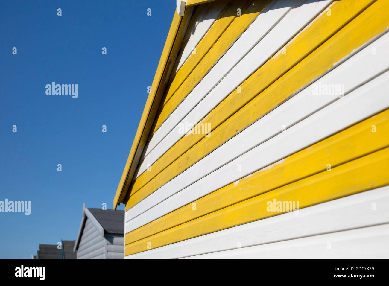 Yellow and white striped wooden beachfront beach hut in Tankerton Kent ...