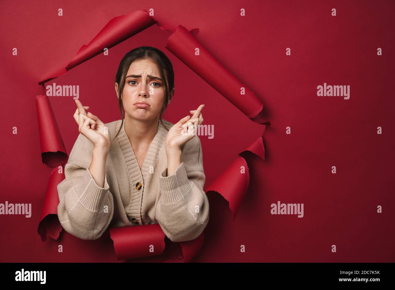 Caucasian young upset woman making sad face with fingers crossed ...
