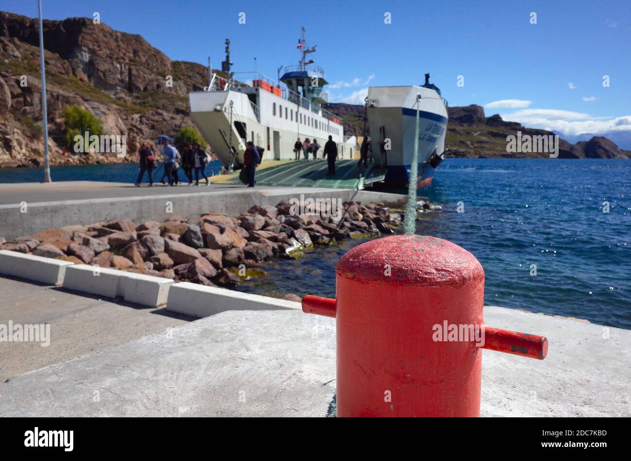 Passenger ferry boat moored on bollard with rope. Red bollard close up ...