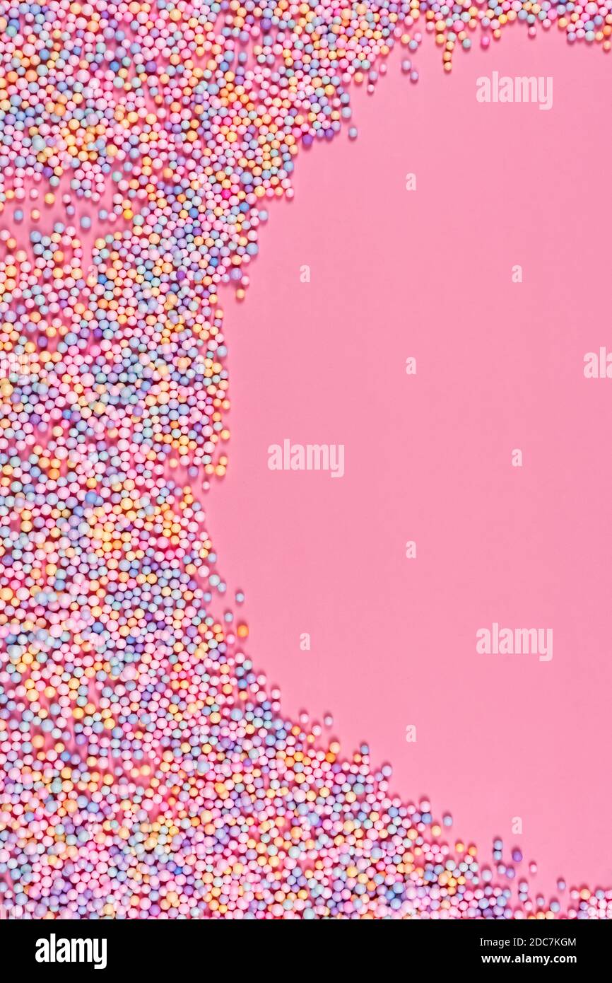 Round frame made of pastel color balls on pink. Styrofoam or ...