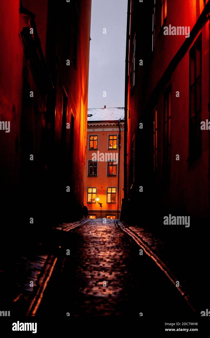 Narrow passage between buildings and a building at dusk Stock Photo - Alamy