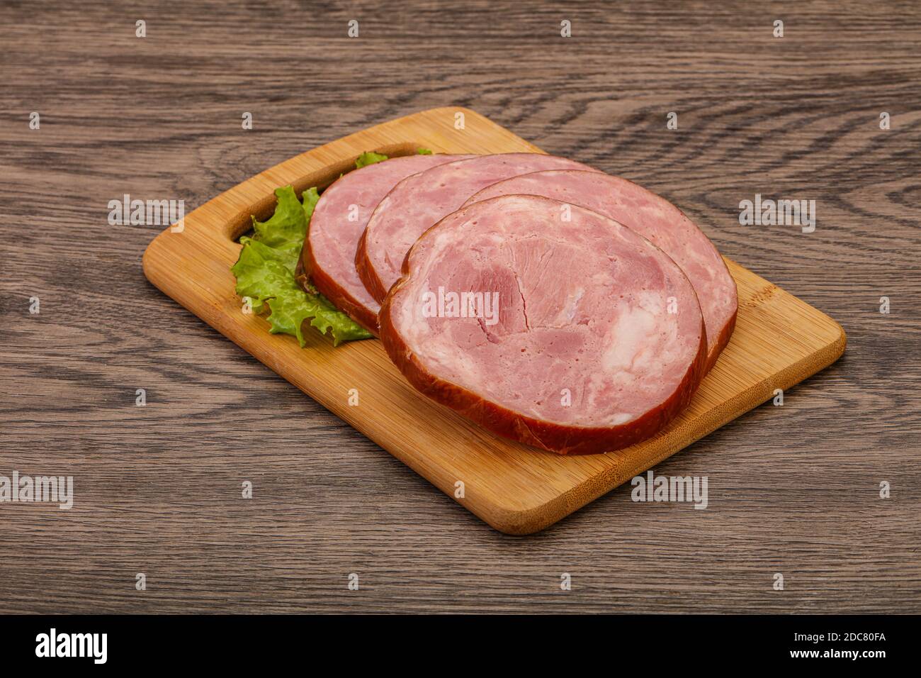 Slices of pork meat ham over wooden board Stock Photo - Alamy