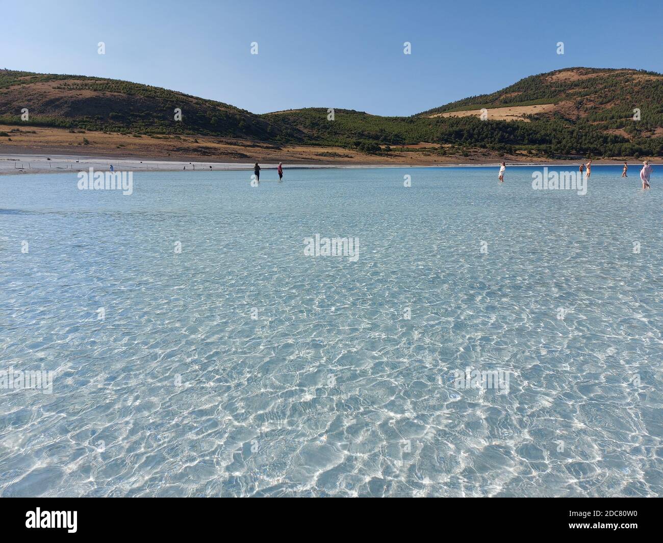 People walk in the shallow blue clear water of Lake Stock Photo - Alamy