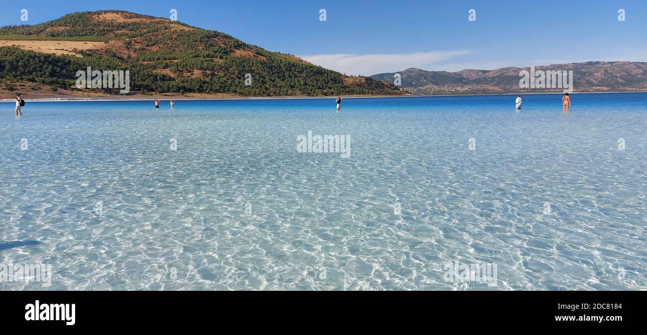 People walk in the shallow blue clear water of Lake Stock Photo - Alamy