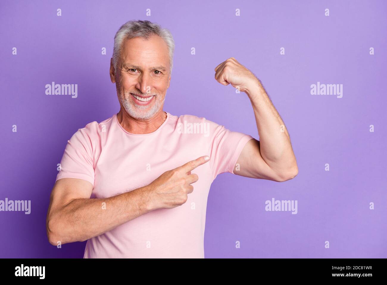 Photo of pensioner old man raise arm direct finger demonstrate biceps ...