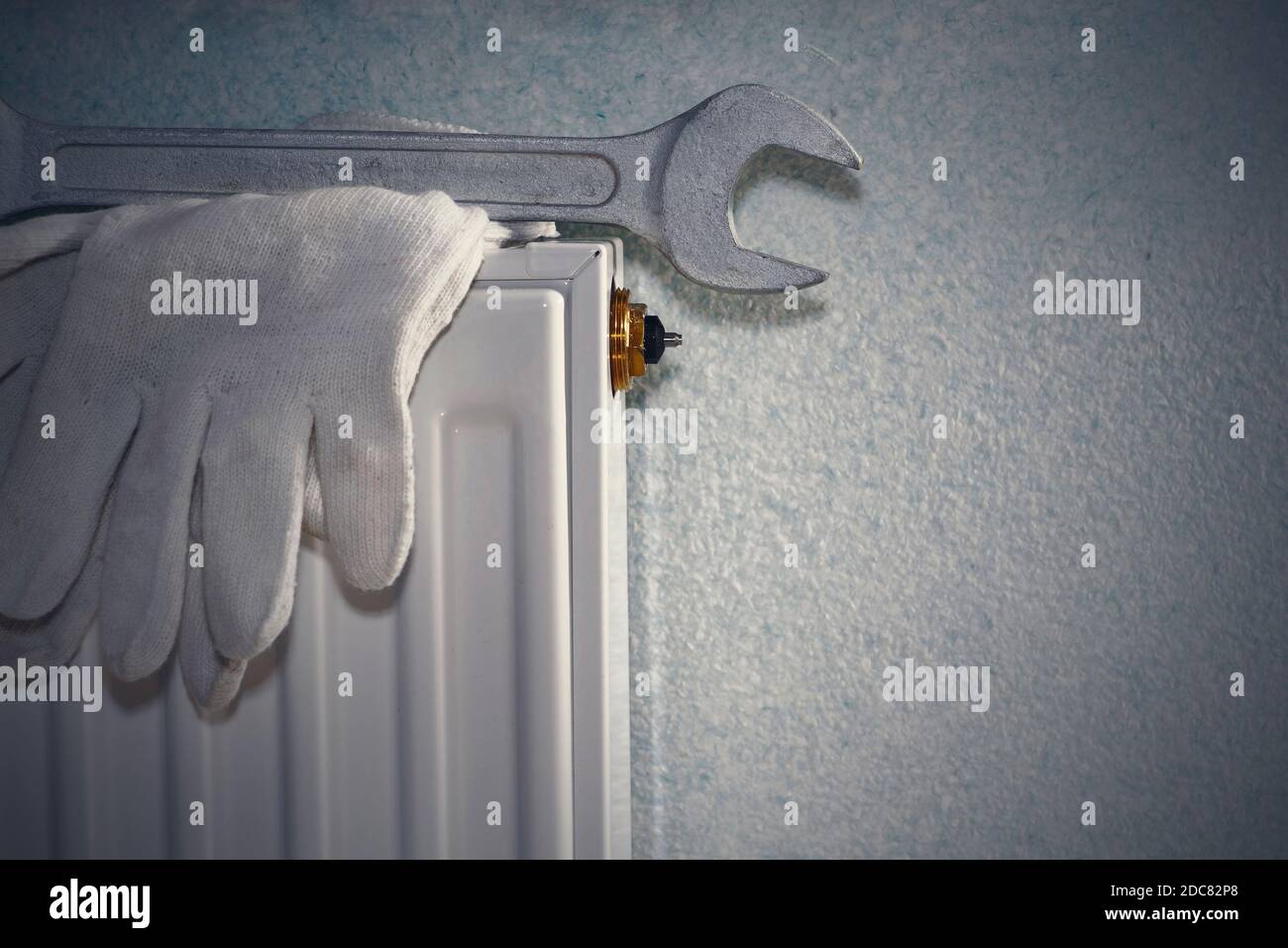 Man is repairing radiator battery in the room. Maintenance repair works ...