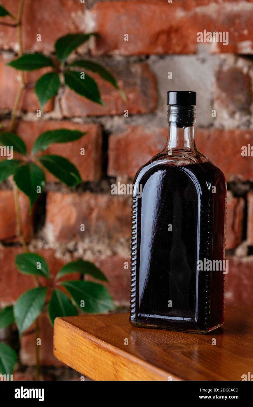 a bottle alcohol on a brick wall background Stock Photo - Alamy