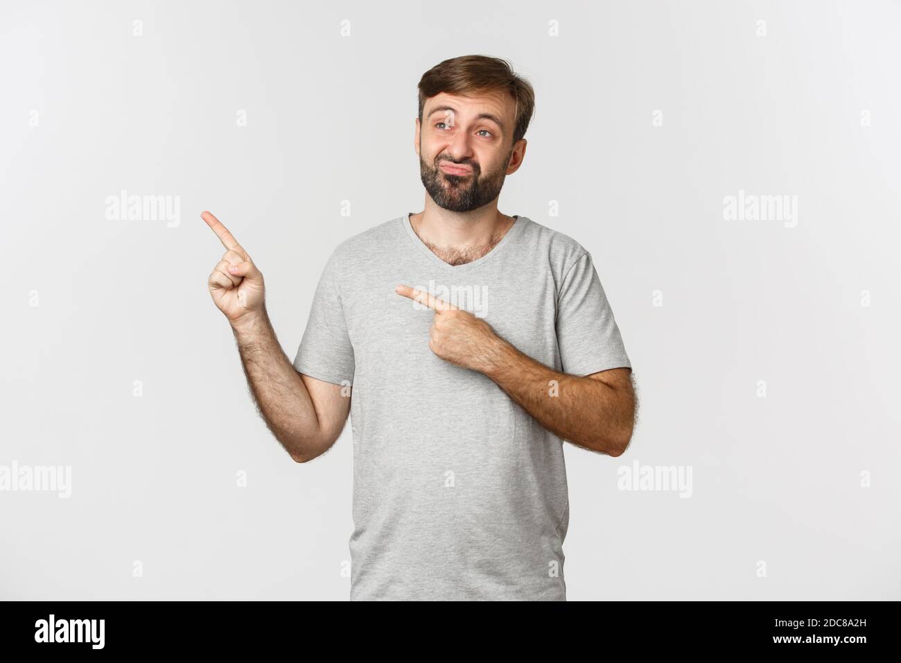 Image of skeptical and unamused bearded guy in gray t-shirt, pouting ...