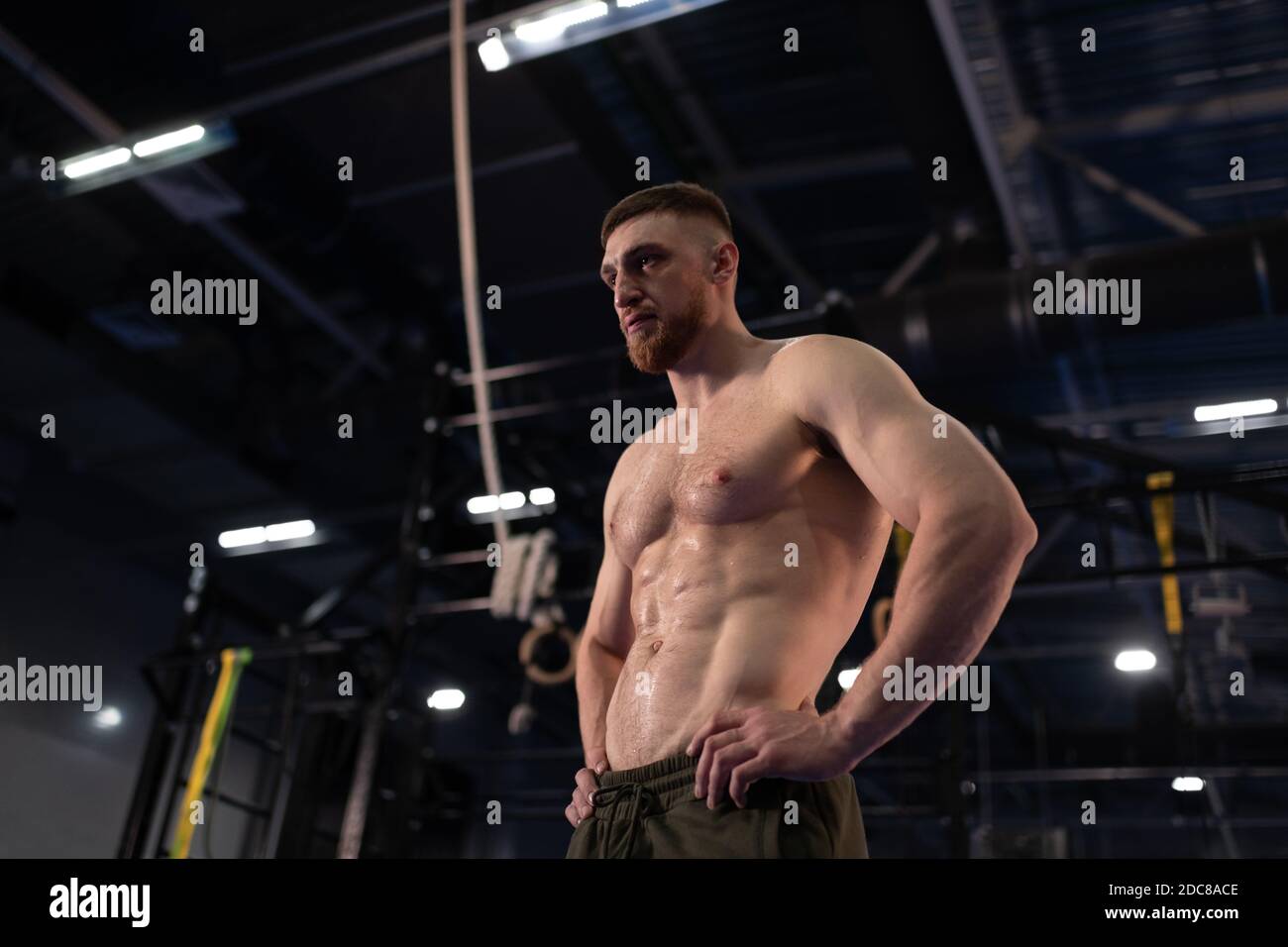 Low angle of focused male athlete with hands on waist preparing for ...
