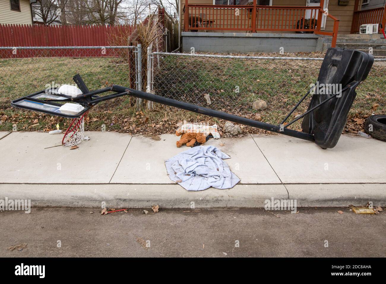 Trash lays on the ground in front of chain link fence in urban area ...