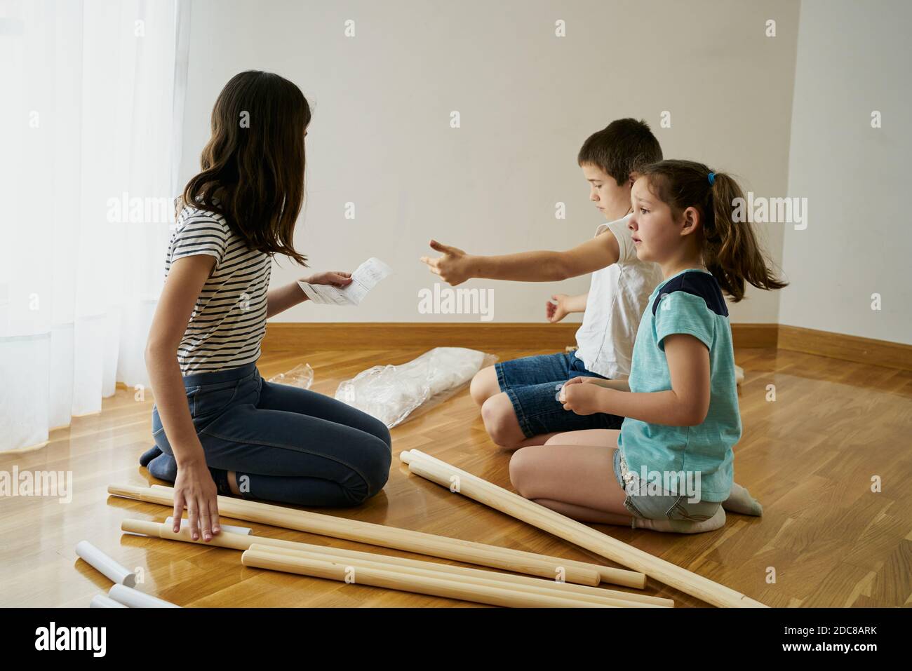 Children setting up a teepee tent inside their house. Childhood concept ...