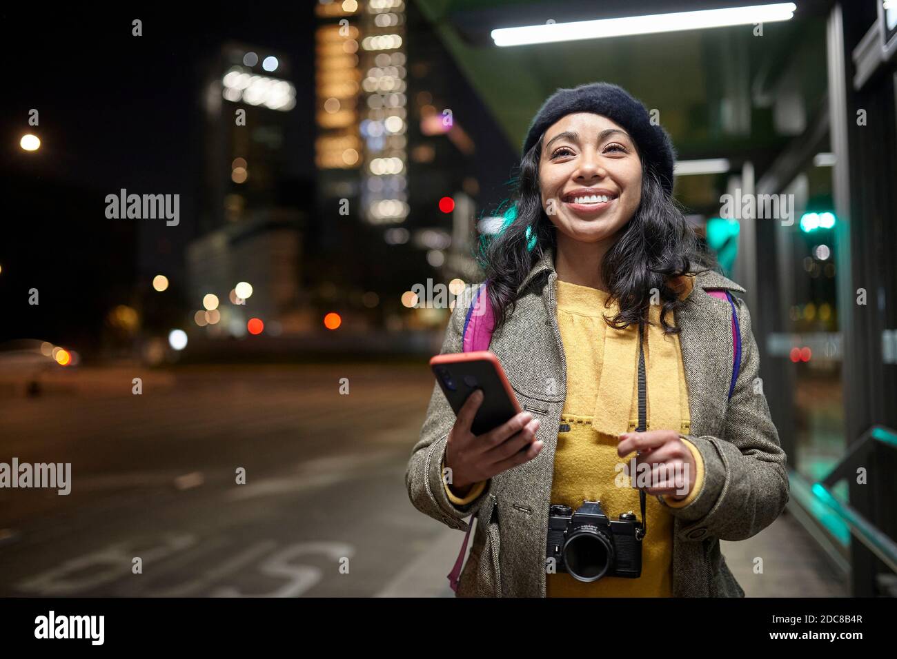 smiling woman standing using his cellphone in the street at night Stock ...