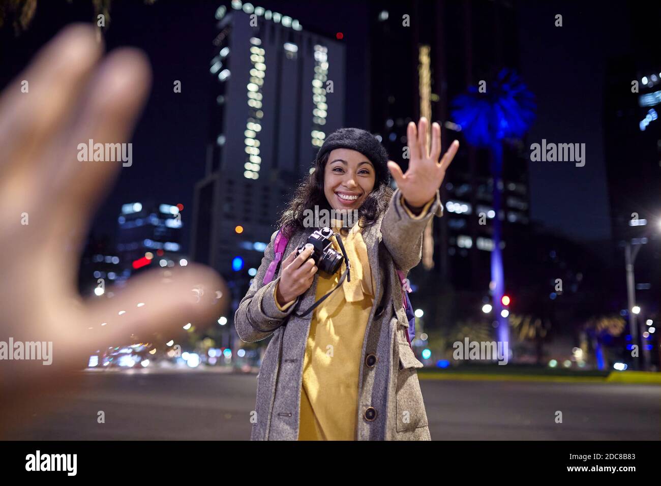 woman saying hello in the streets at night Stock Photo - Alamy
