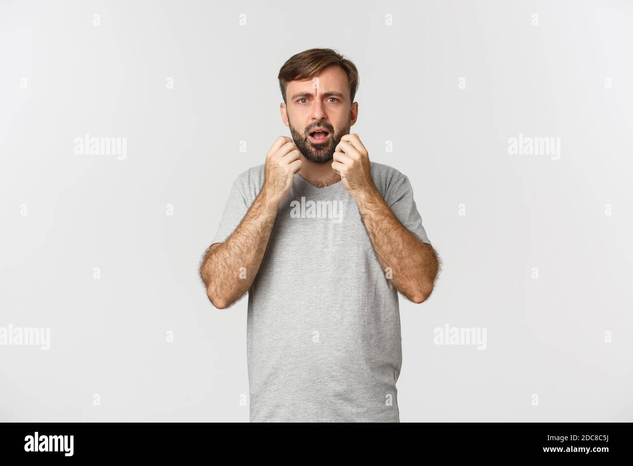 Portrait of horrified and shocked man grimacing, standing anxious over ...