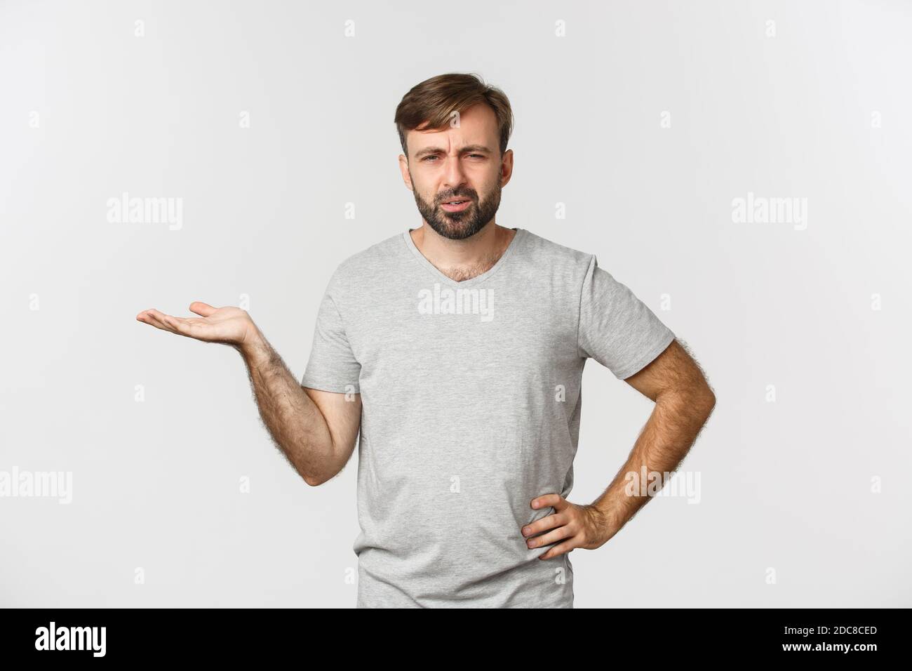 Portrait of confused and annoyed guy arguing, raising hand up and ...