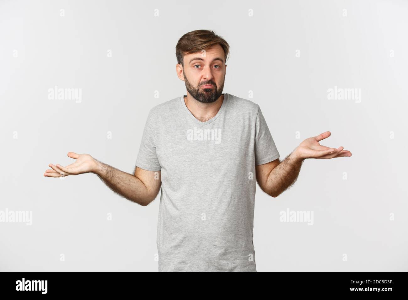 Image of clueless bearded man in casual t-shirt, shrugging and looking ...