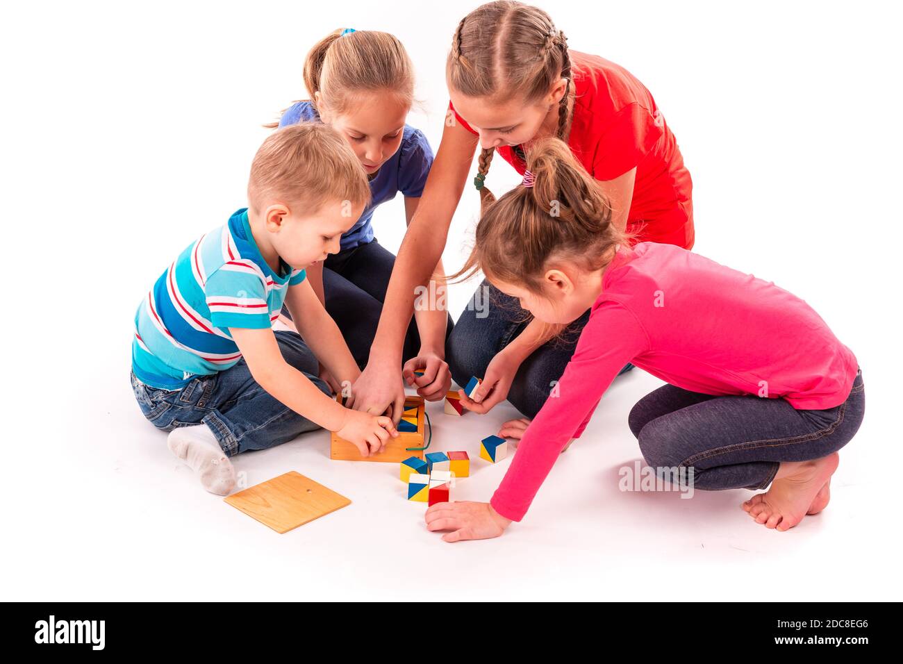 Happy kids playing with building blocks isolated on white. Team work ...