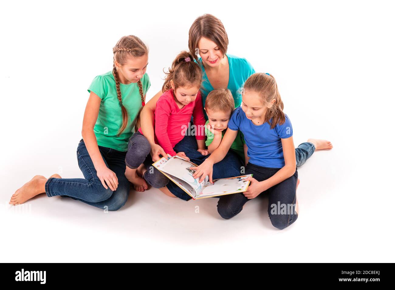 Mother reading a book to children isolated on white. Team work ...