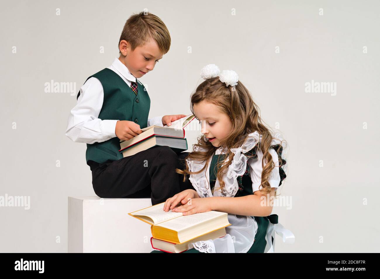 Uniform elementary school students read paper books with interest ...