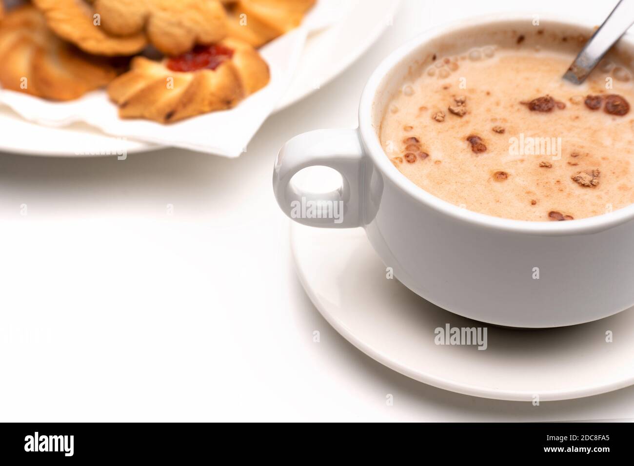 Cup of cocoa with lumps with pastries on white background Stock Photo ...
