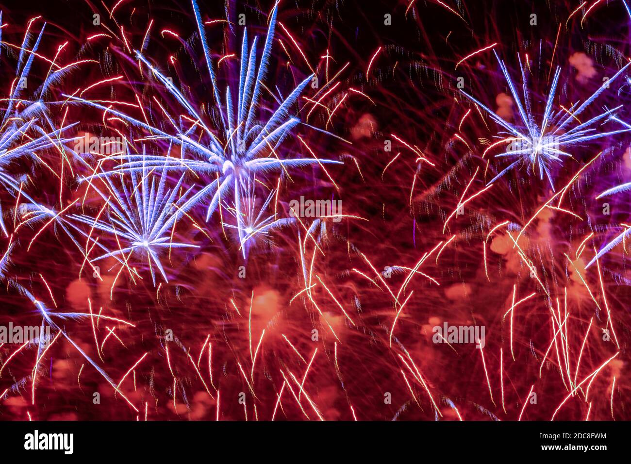 Beautiful multi color fireworks explosions in illuminated sky. Festive ...