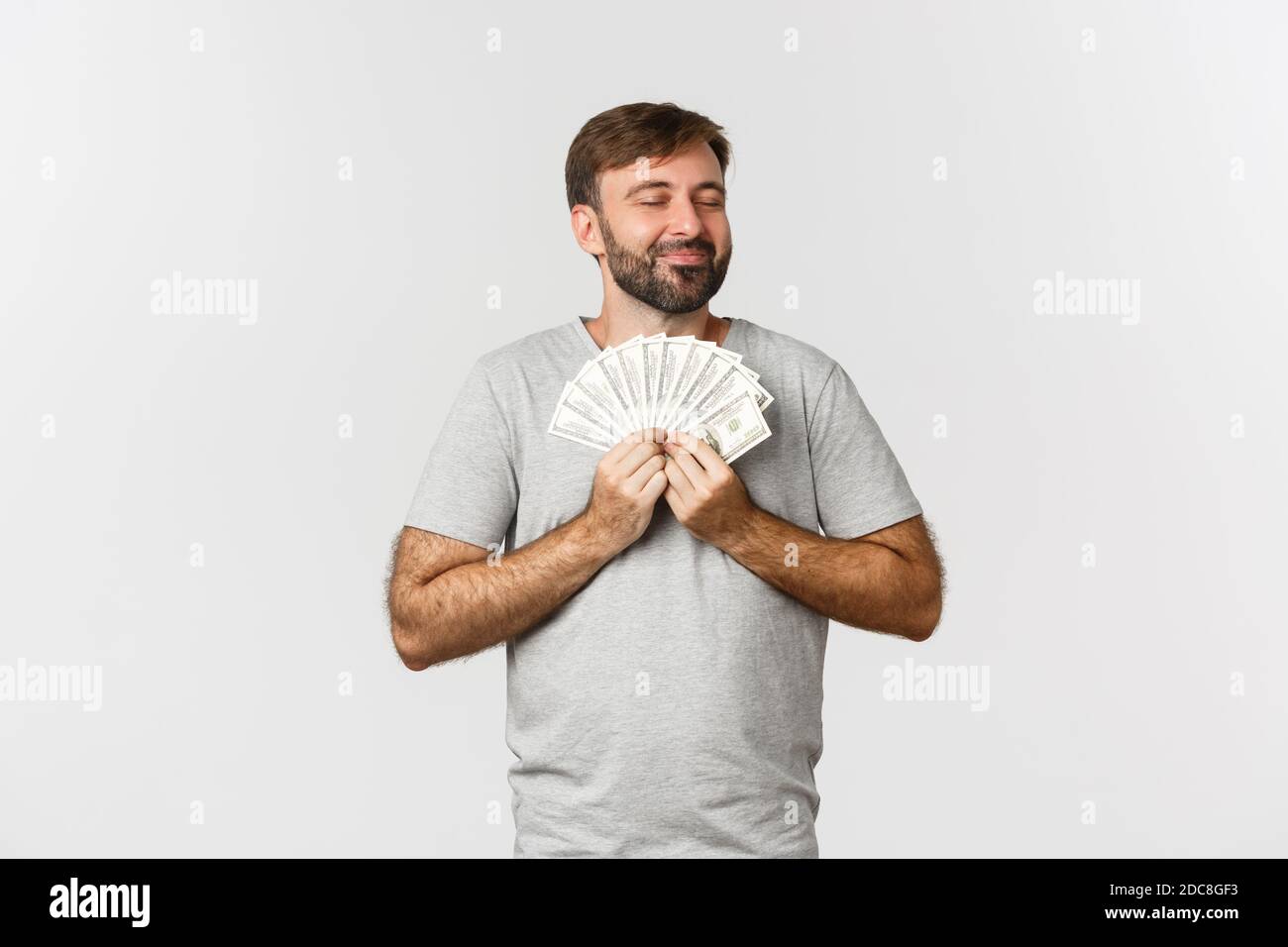 Image of handsome bearded guy who loves money, hugging cash and smiling ...
