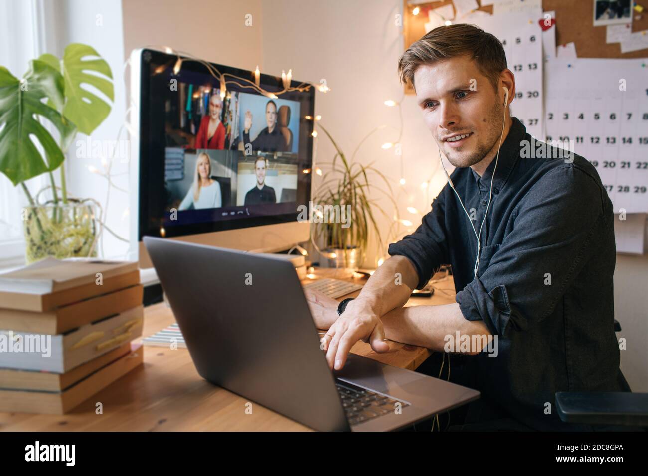 Work from home. Young man having Zoom video call via a computer in the ...
