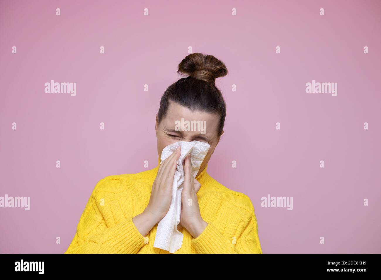 Studio portrait of unhealthy Caucasian female with paper napkin ...