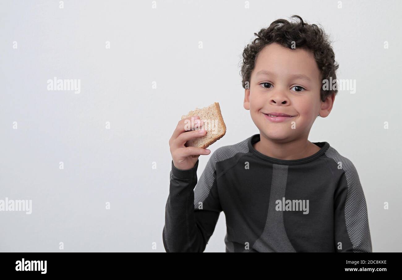 little boy eating toast for breakfast on white background stock photo ...