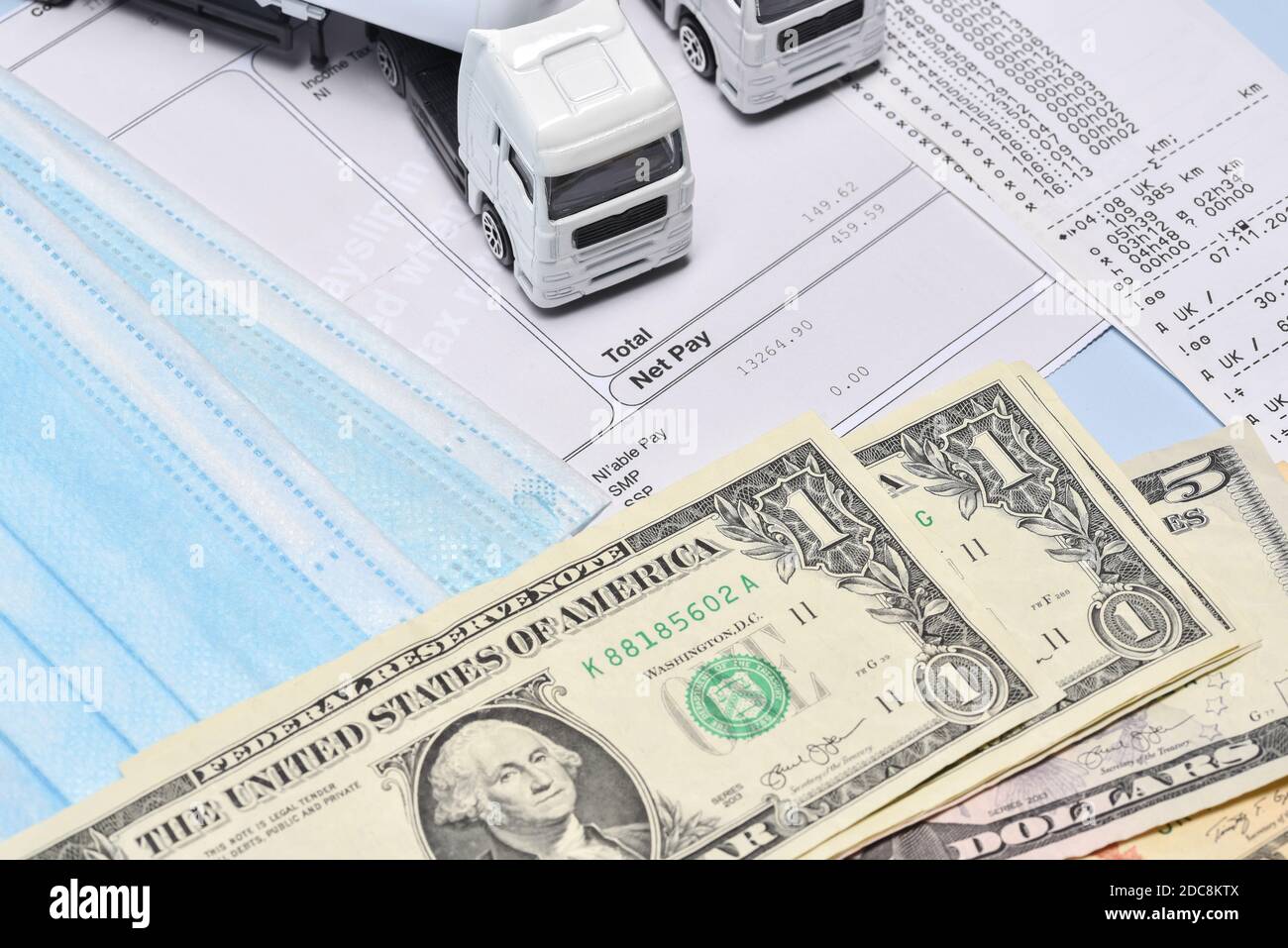 A lorry toys, payroll with dollar bill and face mask in concept about ...