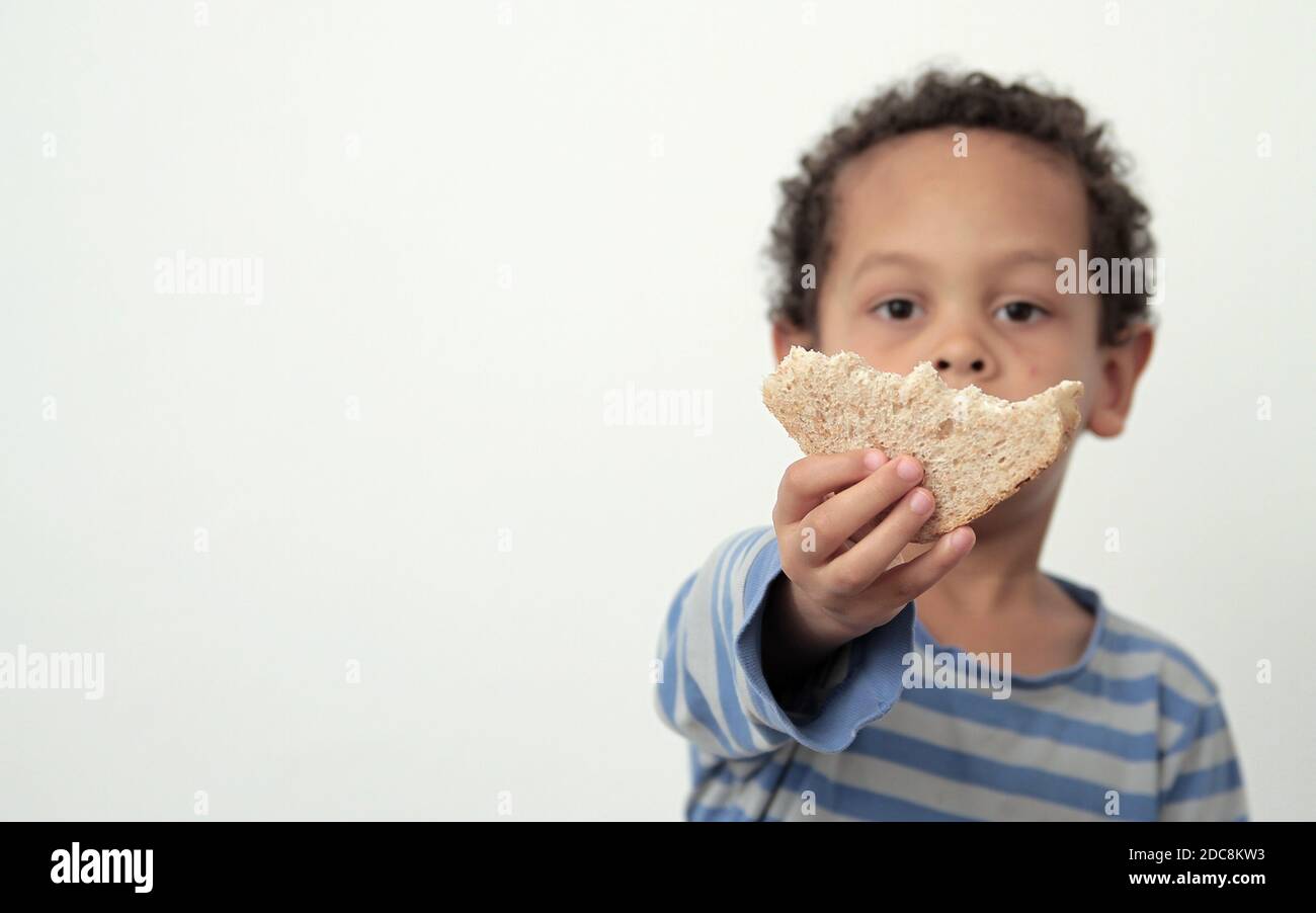 little boy eating toast for breakfast on white background stock photo ...