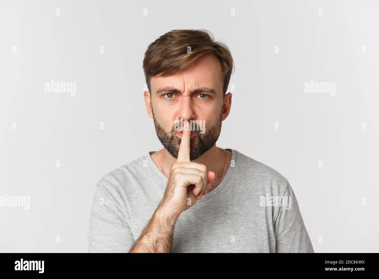 Close-up of angry caucasian man, shushing, telling to be quiet ...