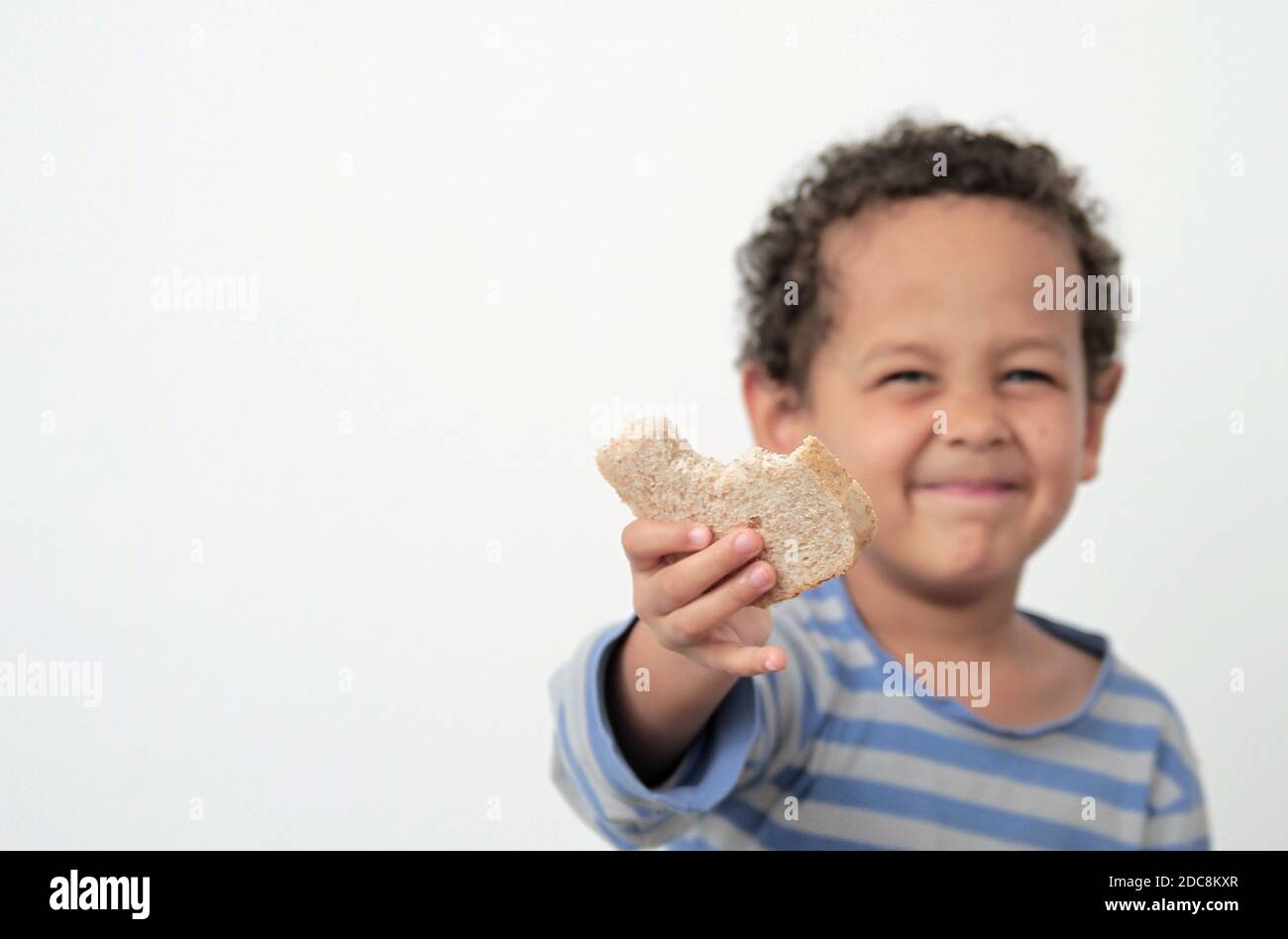 little boy eating toast for breakfast on white background stock photo ...
