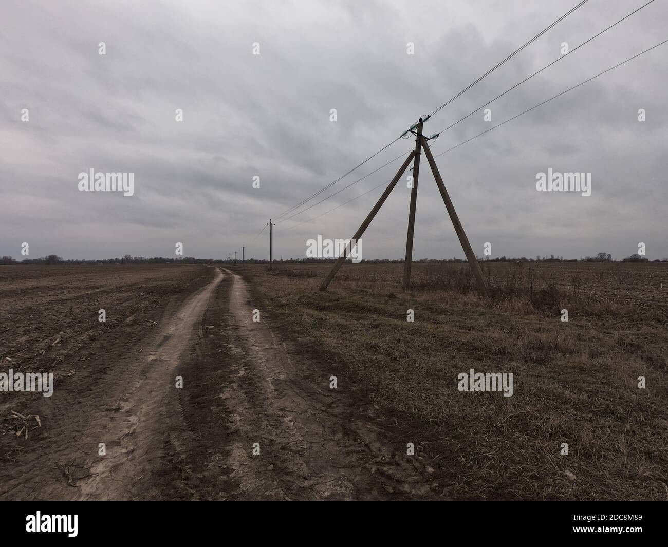 Power lines along a dirt road. Gloomy evening landscape Stock Photo - Alamy