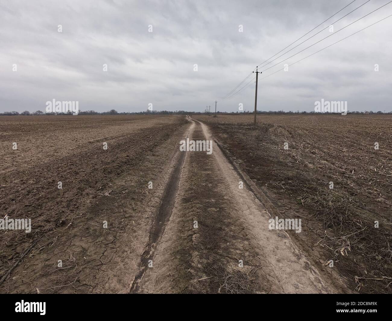 Power lines along a dirt road. Gloomy evening landscape Stock Photo - Alamy
