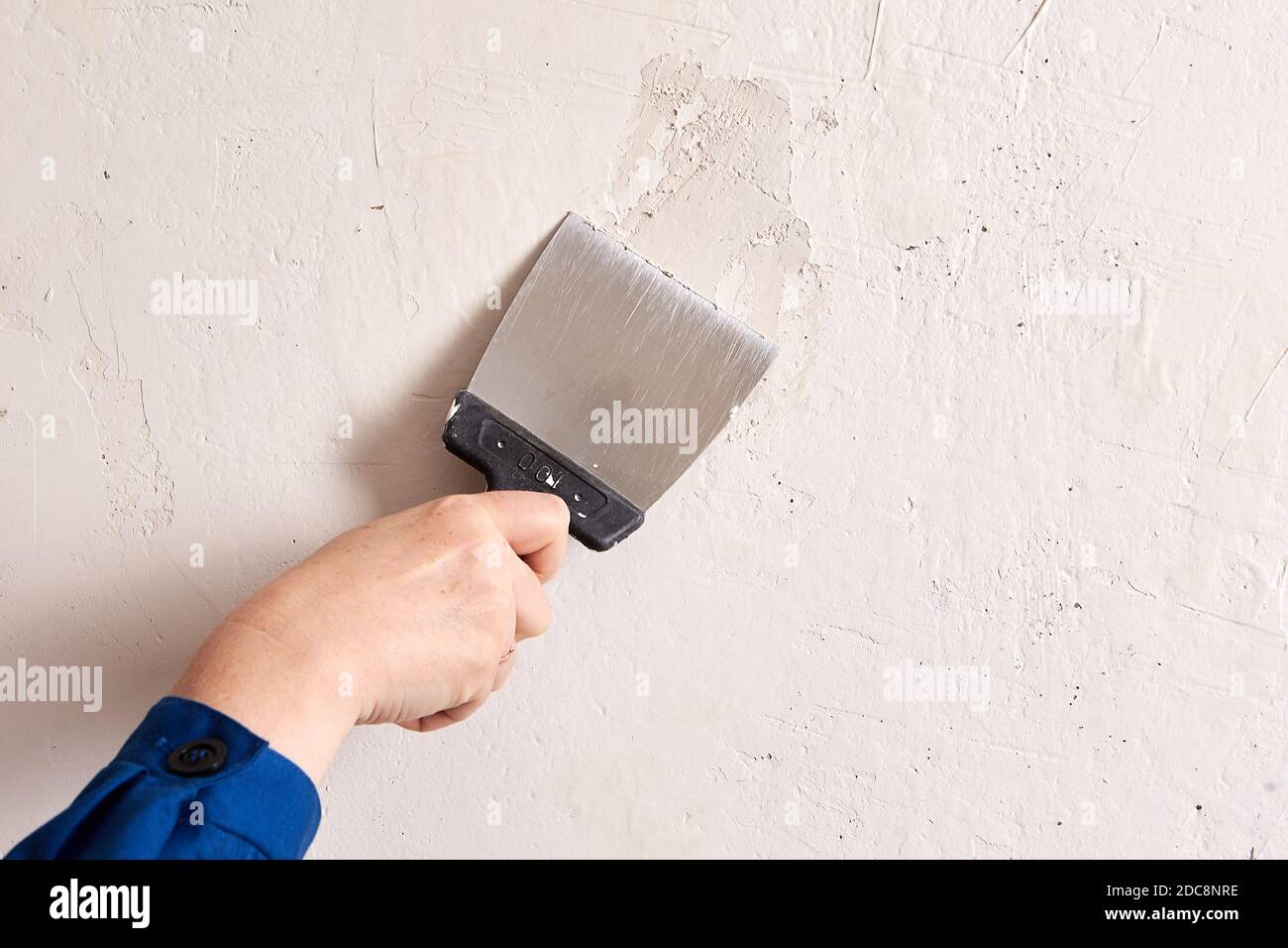 Plasterer uses fine surface filler to fill in any small holes with ...