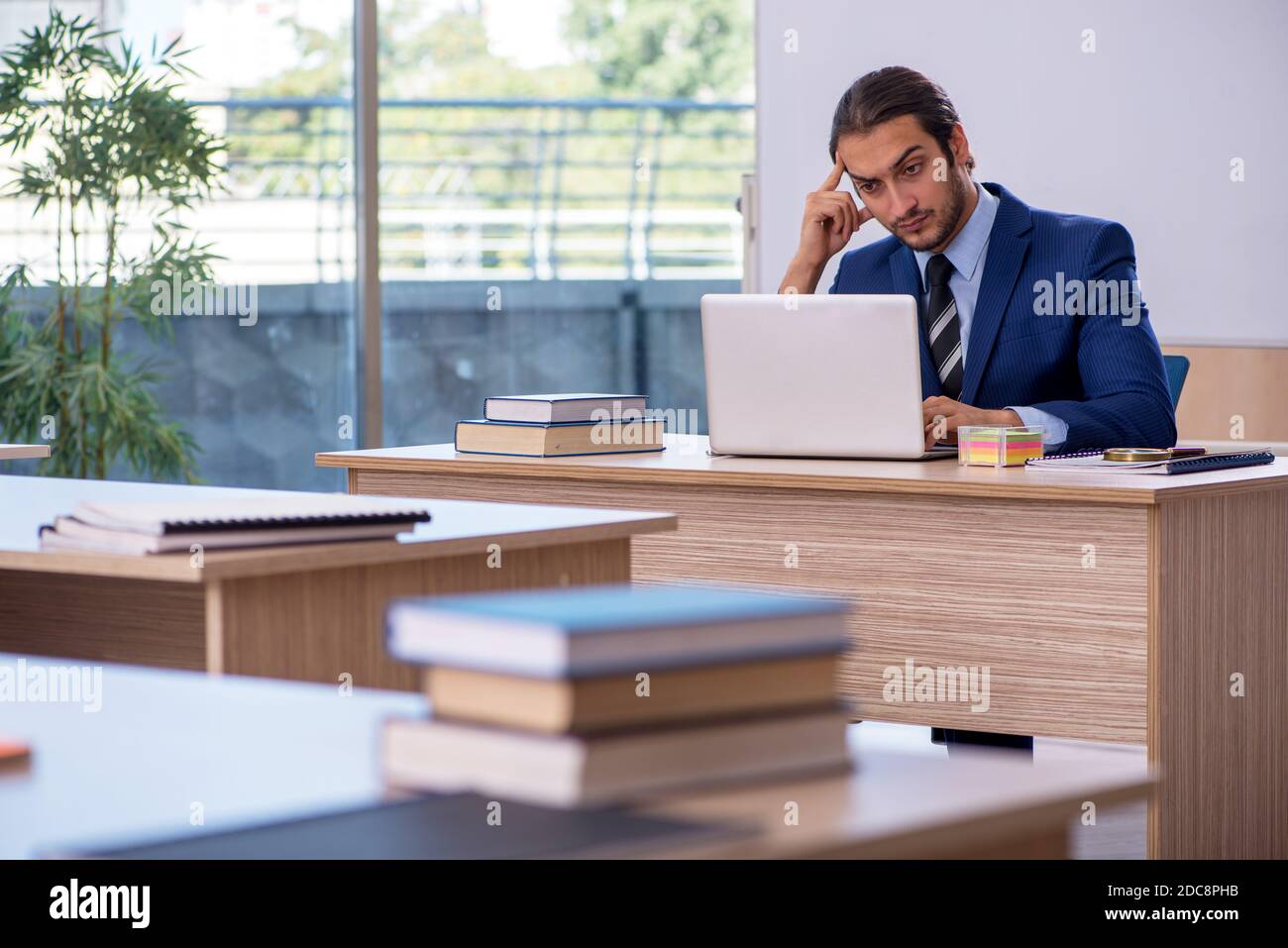Young teacher in suit in the classroom Stock Photo - Alamy