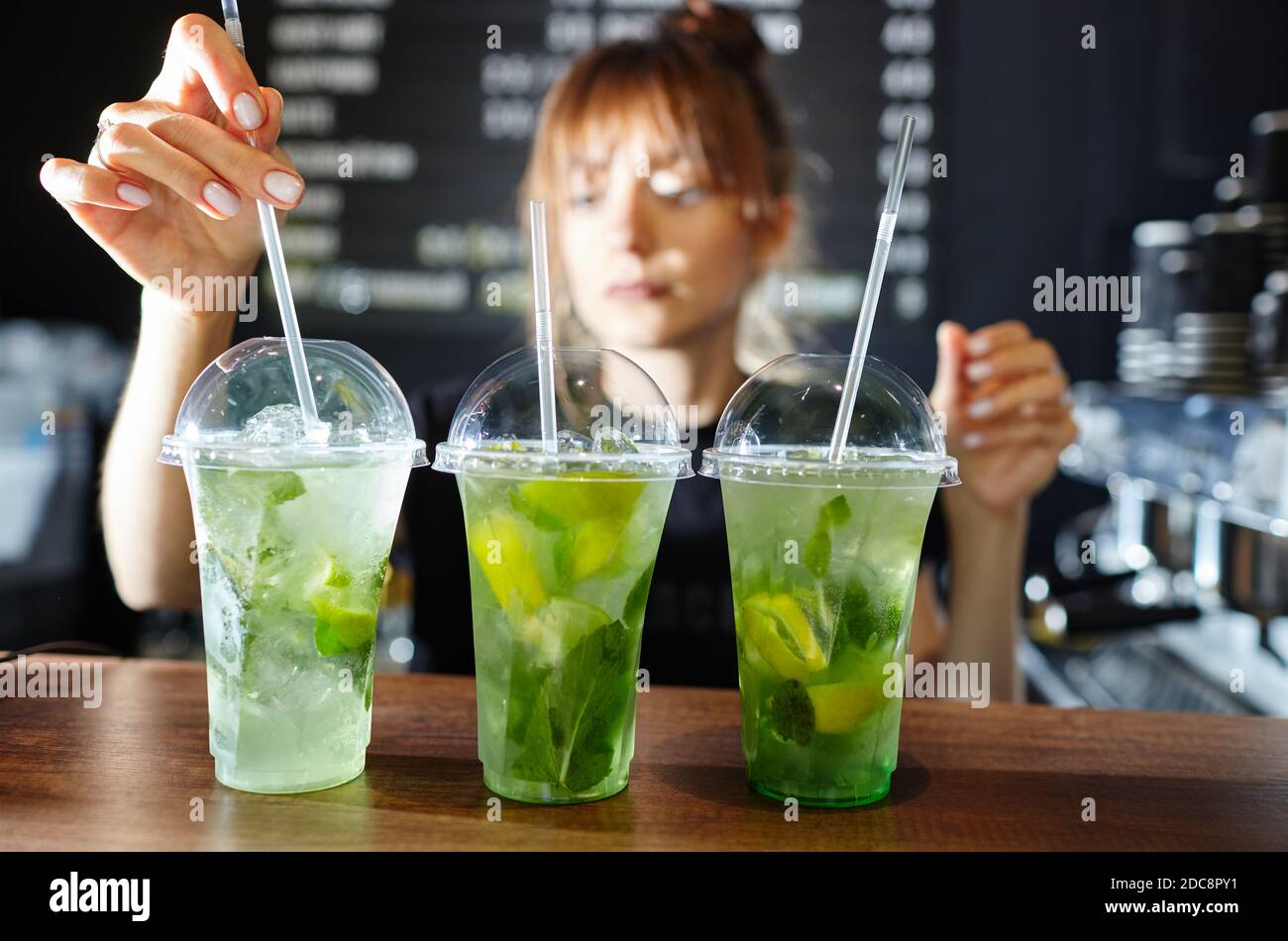Bartender making mojito cocktail. Process of bartending in bar. Fresh cocktail drink with ice ...